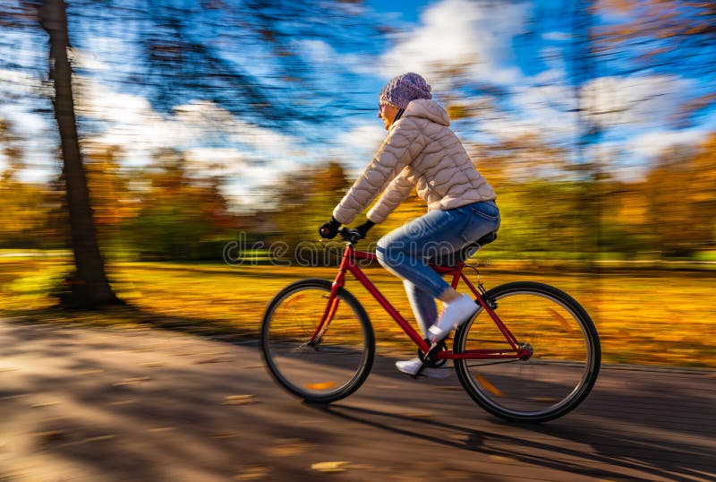 Motion Blur. Mid-adult Woman Riding Bicycle in City Park Stock Image ...