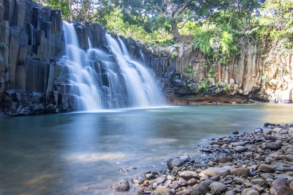 The Waterfall Plunges Over Basalt Steles into a Pool. Tropical Nature ...