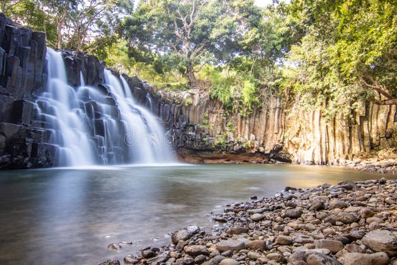 The Waterfall Plunges Over Basalt Steles into a Pool. Tropical Nature ...
