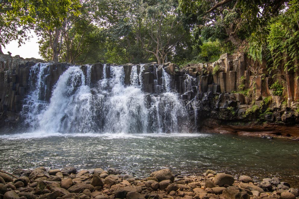 The Waterfall Plunges Over Basalt Steles into a Pool. Tropical Nature ...