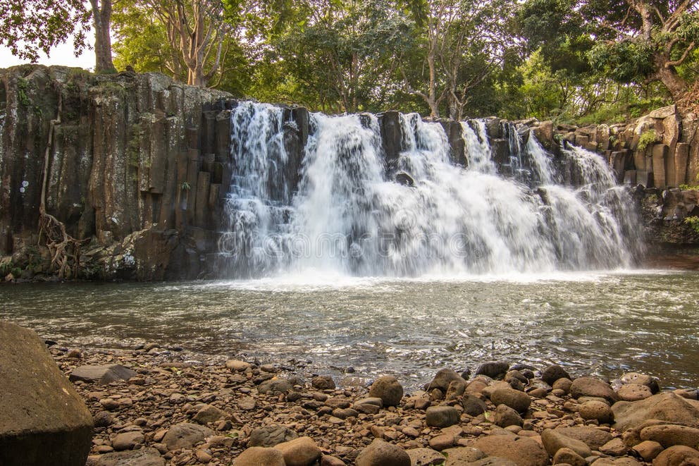 The Waterfall Plunges Over Basalt Steles into a Pool. Tropical Nature ...
