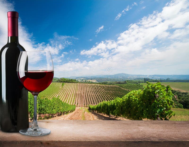 Glass and Bottle of Red Wine Against Vineyard Landscape and Sky with ...