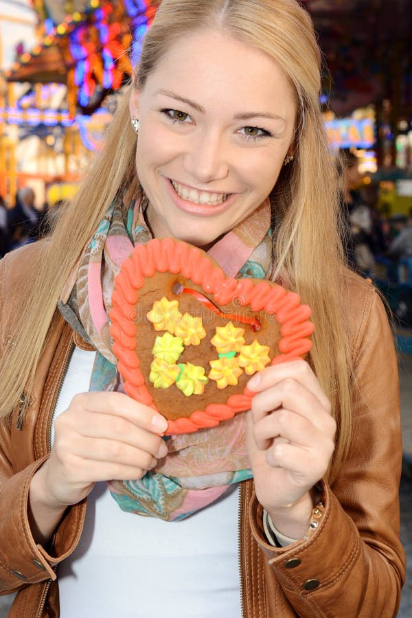 Happy Woman Visits a Fun Fair and Holds a Gingerbread Heart with Candy ...