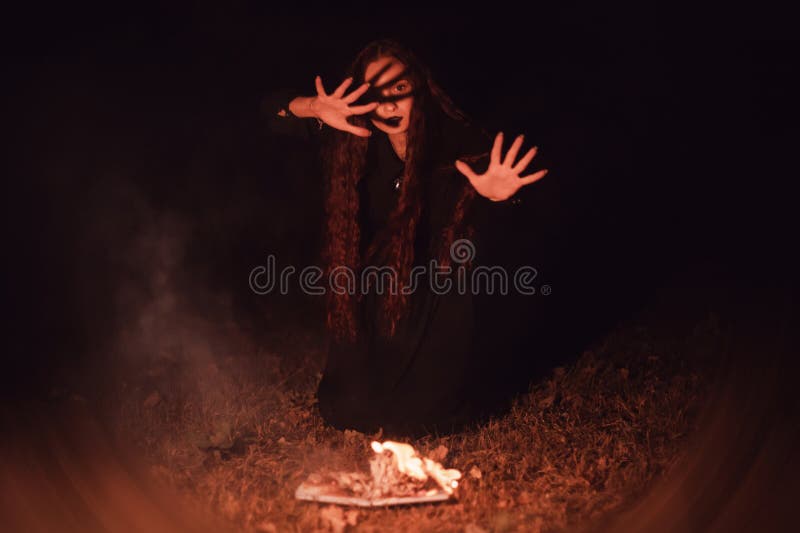 Witch Casts a Spell Over a Burning Book, Halloween, Goth Woman Stock ...