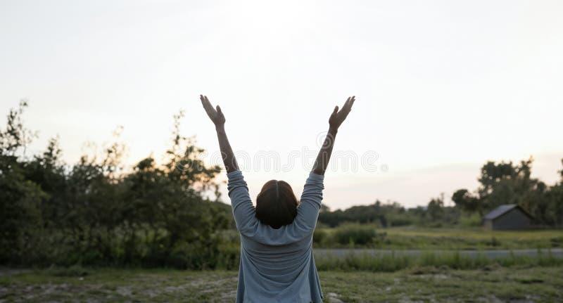 Praising the Lord. a Woman with Her Arms Raised To the Sky in ...