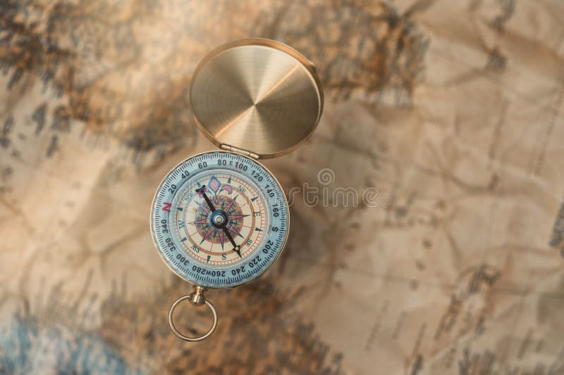 Antique Brass Compass Resting on a World Map, Symbolizing Travel and ...