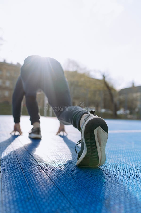 Athlete Runner Starts Running on the Blue Field. Rear View Stock Photo ...