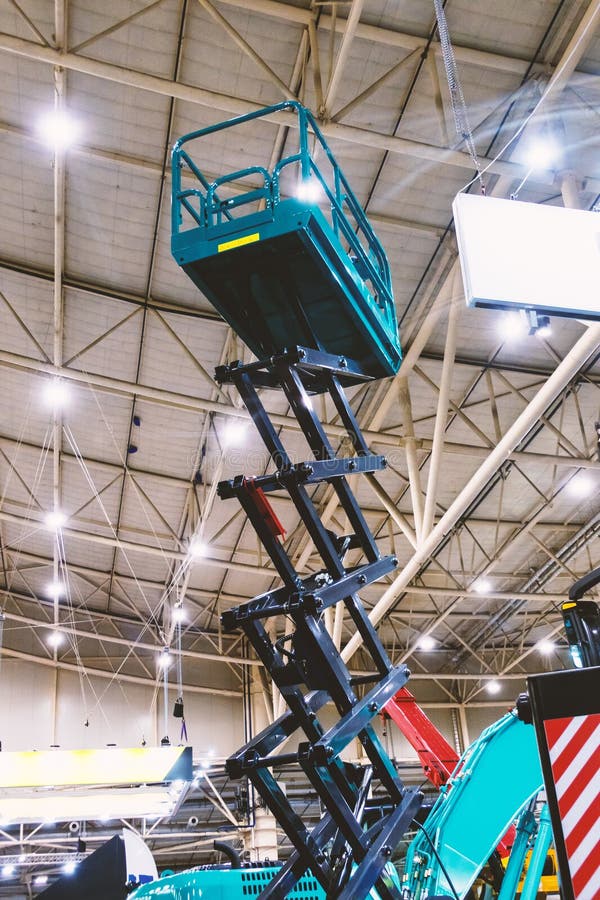 A Blue Scissor Lift is Positioned in a Large Industrial or Warehouse ...