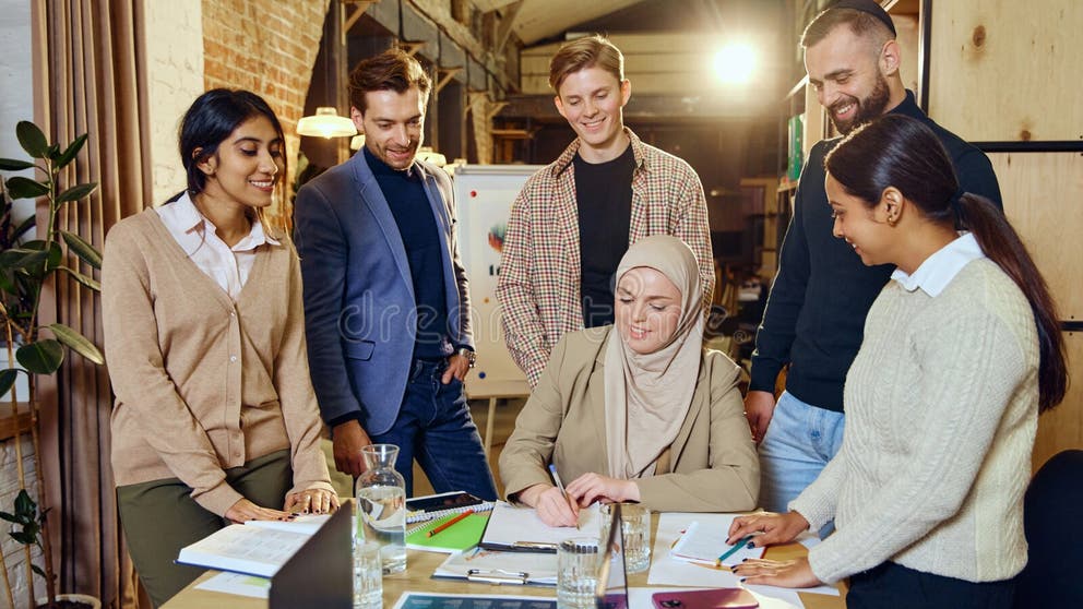 Diverse Group of Young Professionals Gathered Around Table, Discussing ...