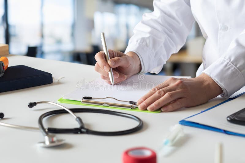 Doctor at a Table Making a Note in a Document Stock Photo - Image of ...