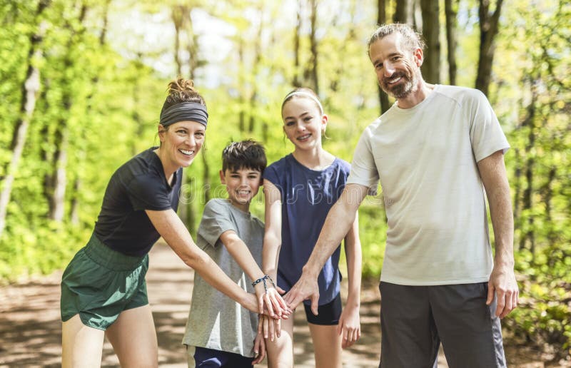 A Family Exercising and Jogging Together at an Outdoor Park Hand on ...