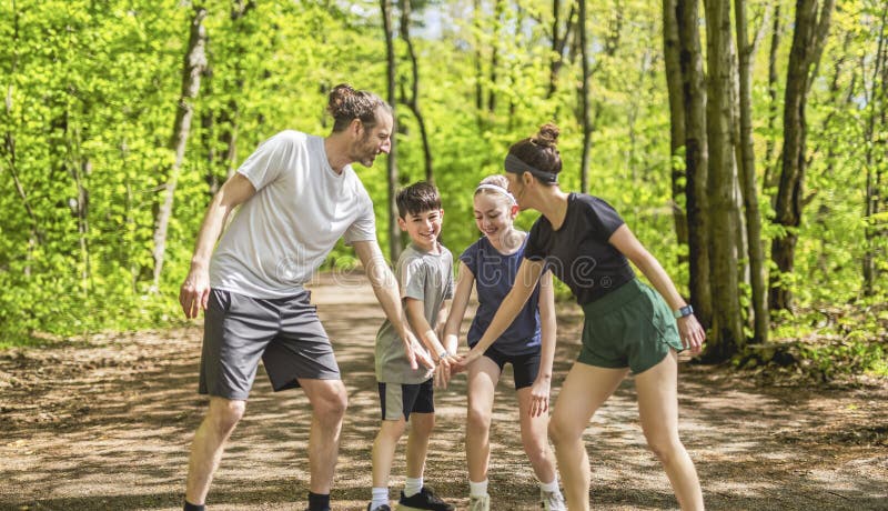 A Family Exercising and Jogging Together at an Outdoor Park Hand on ...