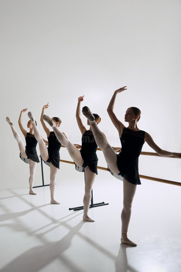 Four Teens Girls, Ballet Dancers Practicing at Barre, Extending Arm in ...