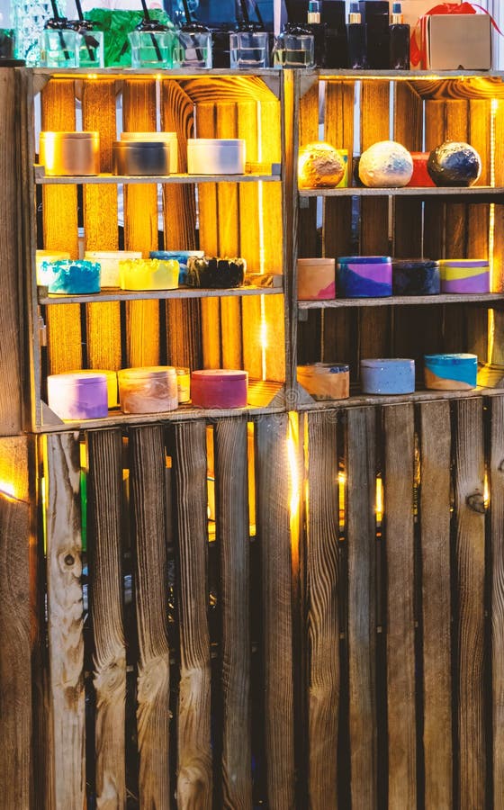 A Shelf Filled with Containers of Different Colors with Scented Candles ...