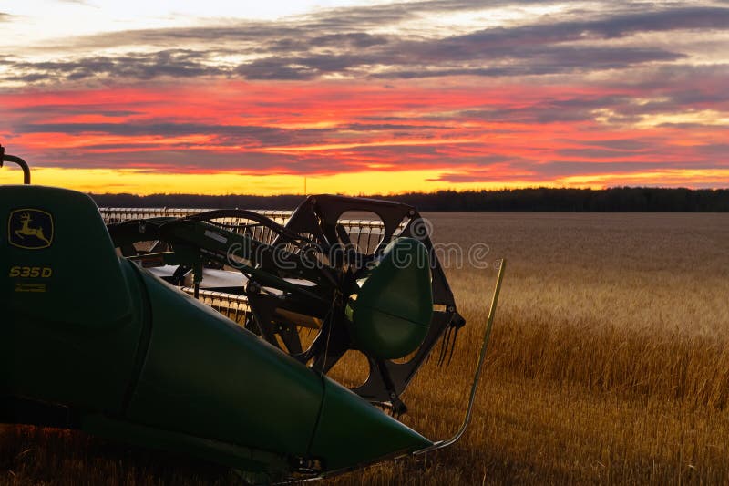 Header 650d of John Deere Combine in the Wheat in Sunset. Editorial ...
