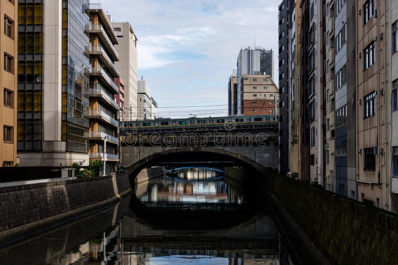The Train is Going through the City. Canal with Charming Buildings and ...