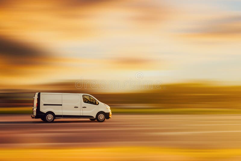 A White Van is Driving Down the Street at Speed with a Blurred ...