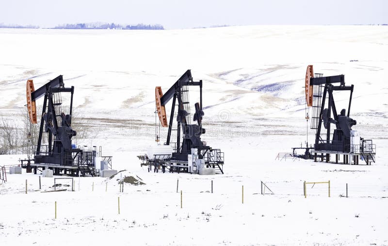 Working Pump Jacks in a Row on Snow Covered Prairie Fields in Central ...