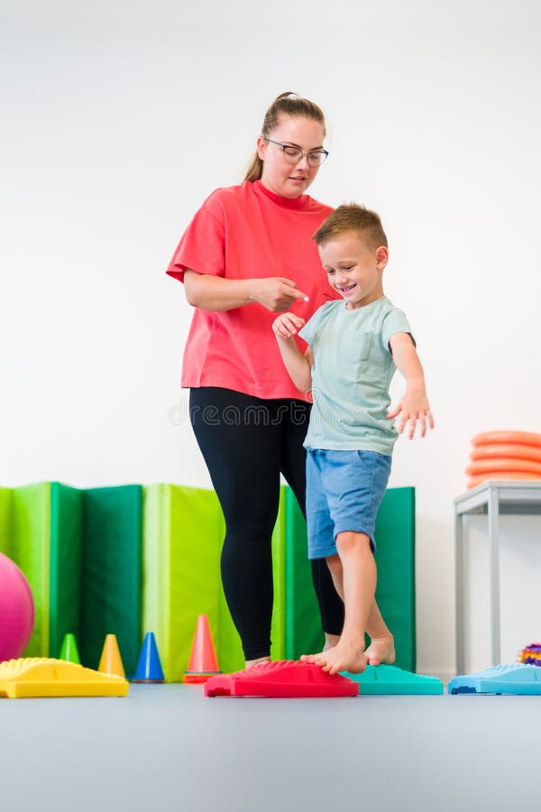 Young Boy Exercising with Female Physical Therapist during Therapy ...