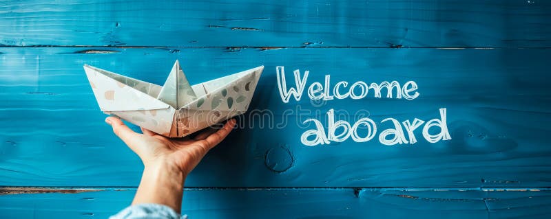 Hand Presenting a Paper Boat with the Message Welcome Aboard Against a ...