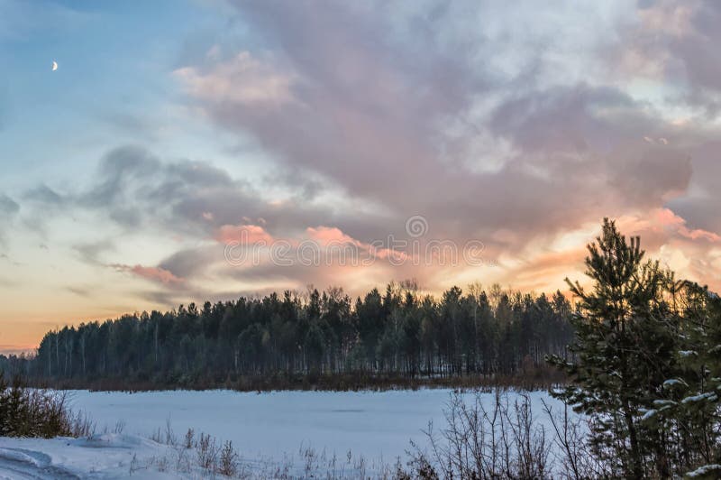 A Gentle Sunset Over a Forest and a Snow-covered River. the New Moon ...