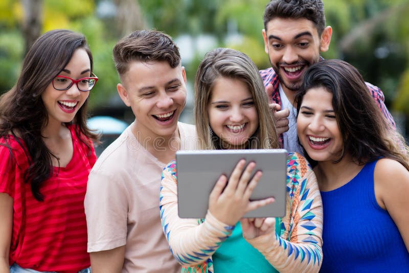 German Female Student with Tablet Computer and Group of Cheering ...