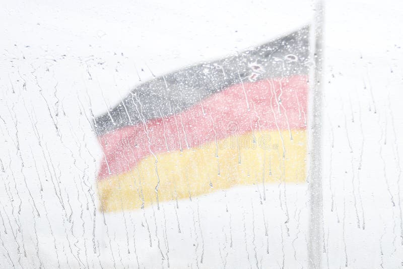 German Flag on a Blurred Background Behind Glass in the Rain, a Sad ...