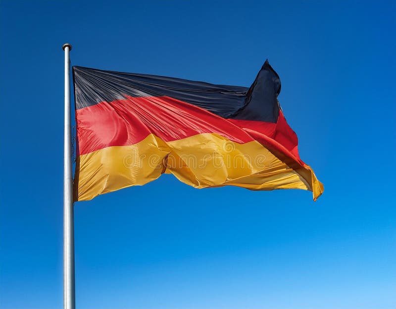 German Flag Soaring High Against a Clear Blue Sky, Highlighting the ...