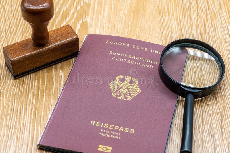 A German Passport is Stamped on a Wooden Table in an Official Process ...