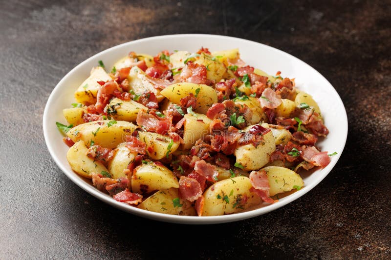German Potato Salad with Bacon and Herbs in a White Plate Stock Photo ...