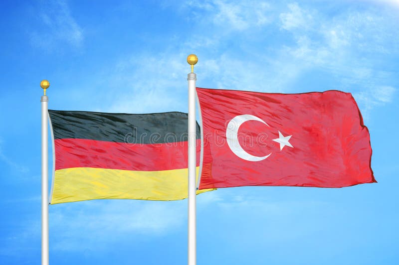 Germany and Turkey Two Flags on Flagpoles and Blue Cloudy Sky Stock ...