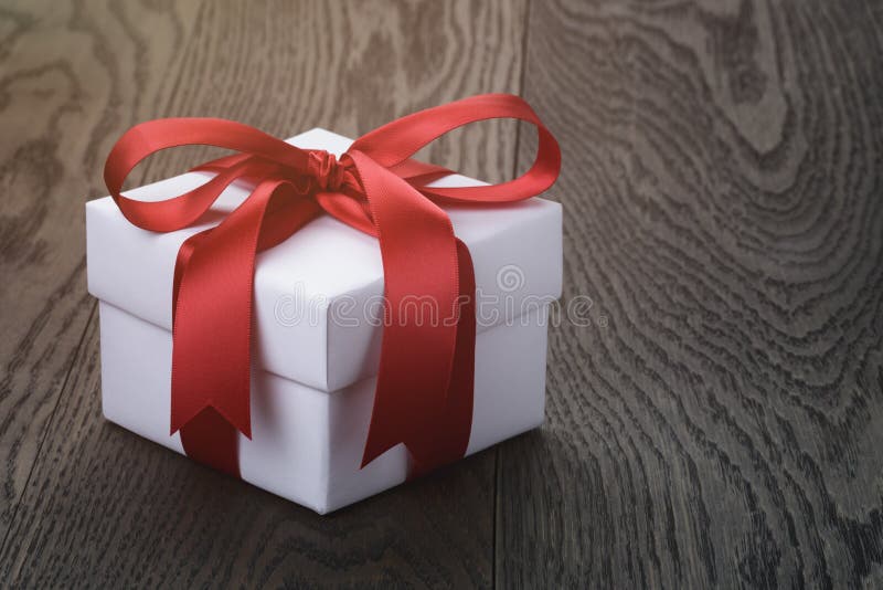 Geschenkbox Mit Rotem Bogen Auf Rustikaler Tabelle Stockfoto - Bild von ...