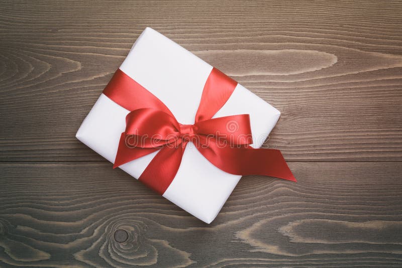Geschenkbox Mit Rotem Bogen Auf Rustikaler Tabelle Stockfoto - Bild von ...