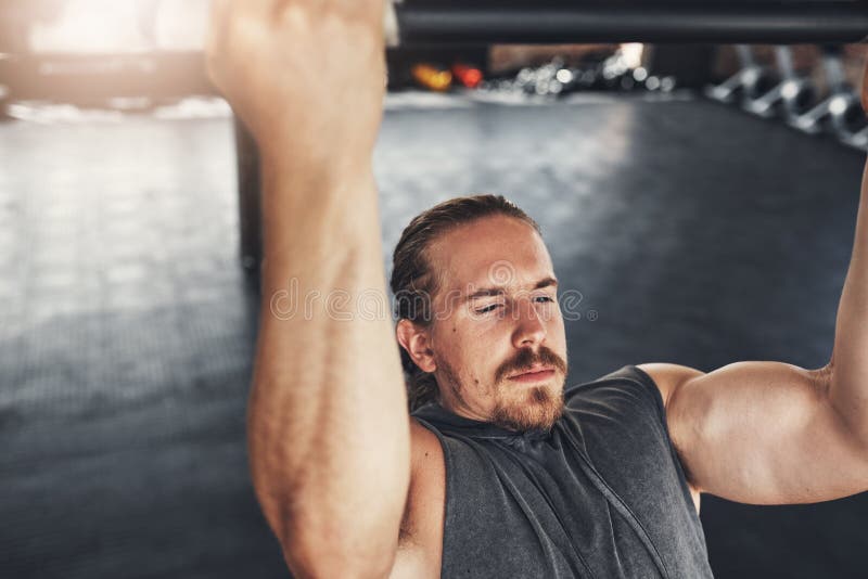 Get a Firm Grip on Your Goals. a Young Man Doing Pull Ups in a Gym ...