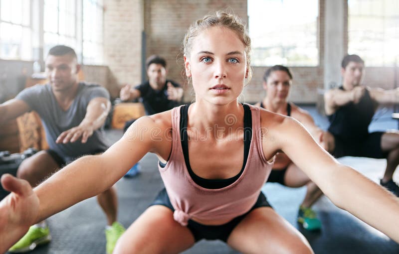 Get Fit or Go Home. a Group of People Doing Squats in a Gym. Stock ...