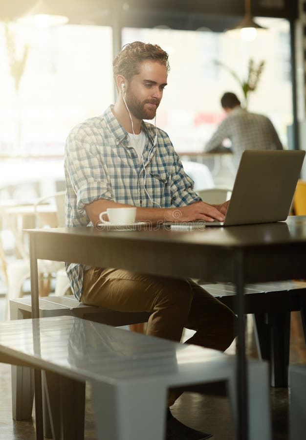 Getting into the Flow of Things. a Young Man with Earphones Using a ...