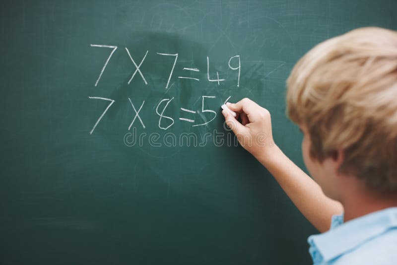 Getting Good at Mathematics. a Young Boy Doing His Sums on a Blackboard ...