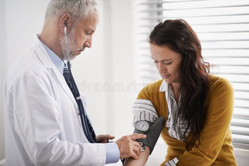 Getting Her Annual Checkup. a Doctor Checking a Patients Blood Pressure ...
