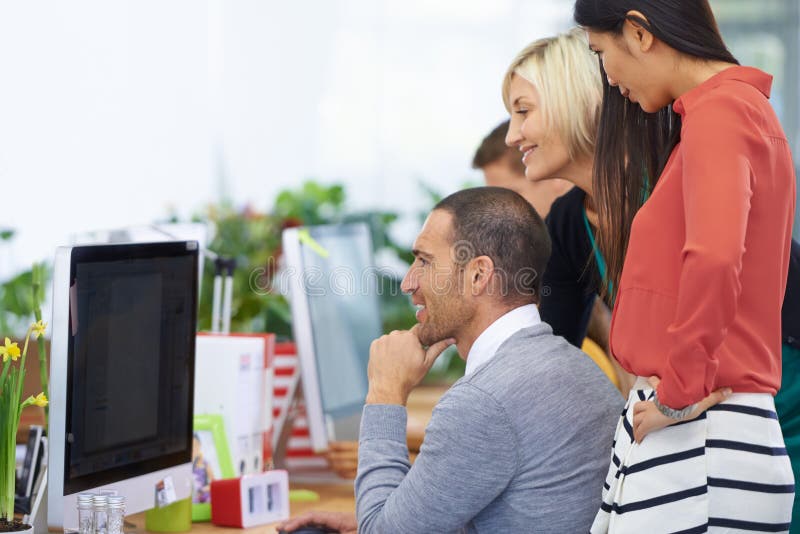 Getting the Job Done. Three Coworkers Working Around a Single Computer ...