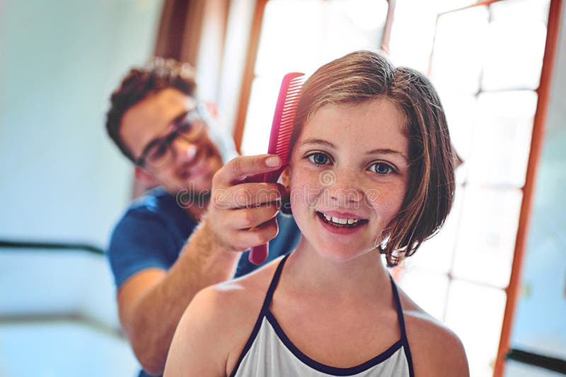 Getting Ready with Some Help from Dad. a Father Combing His Little Daughters Hair at Home. Stock ...