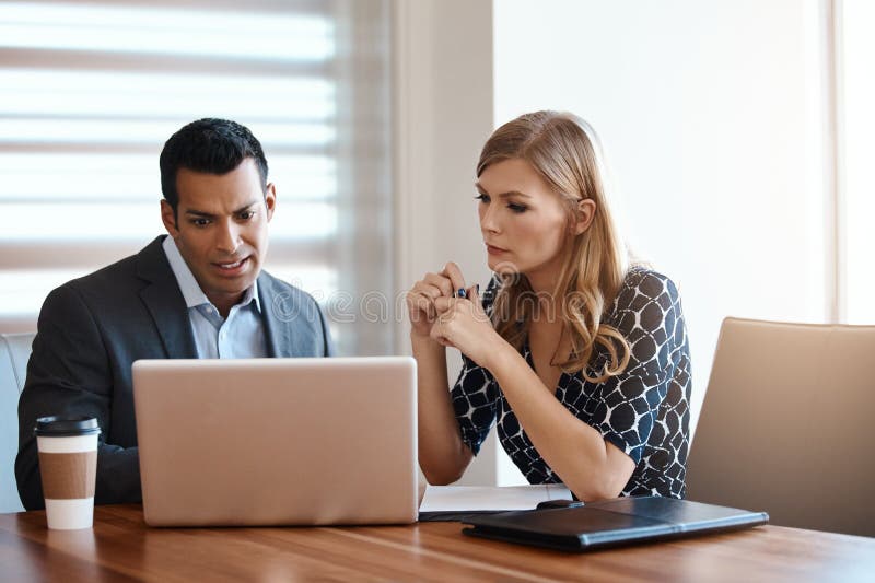 Getting Some Advice. Two Young Businesspeople Working Together in a ...