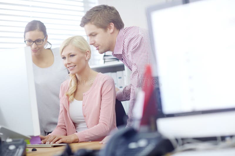 Getting Their Thoughts. Three Young Coworkers Gathered Around a Single ...