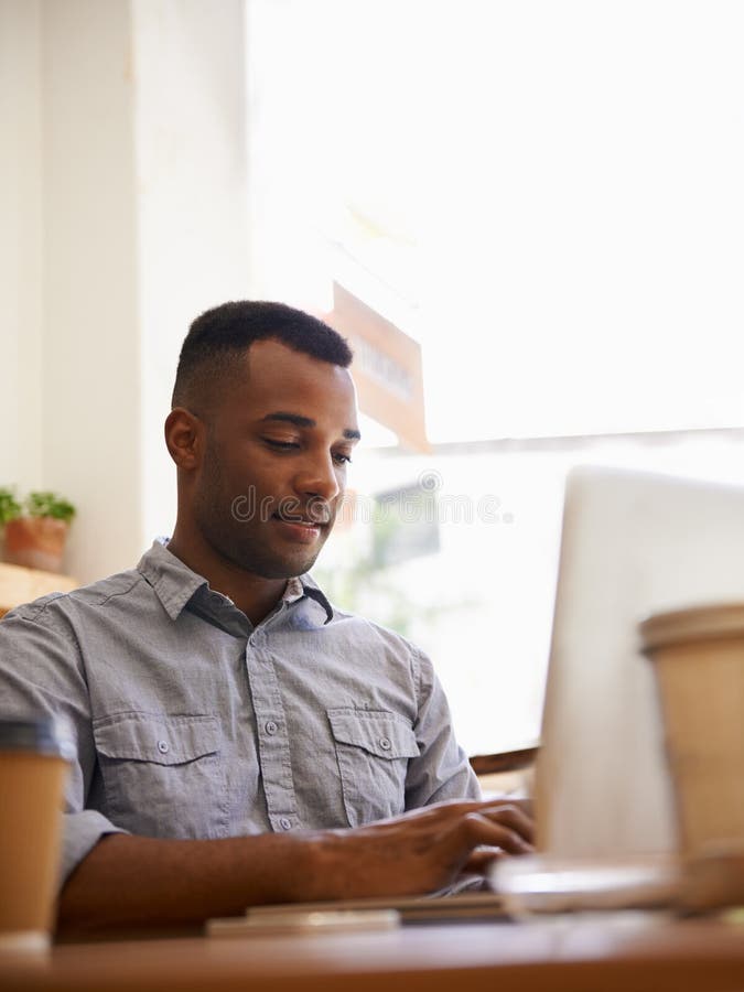 Getting the Work Done with the Help of Coffee. an African Man Using His ...