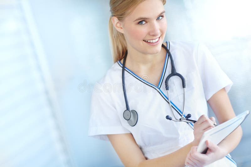 Getting Your Health Details. Portrait of a Smiling Nurse Writing Notes ...