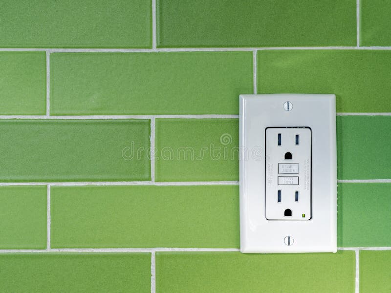A GFCI (Ground Fault Circuit Interrupter) Electrical Outlet on a Green ...