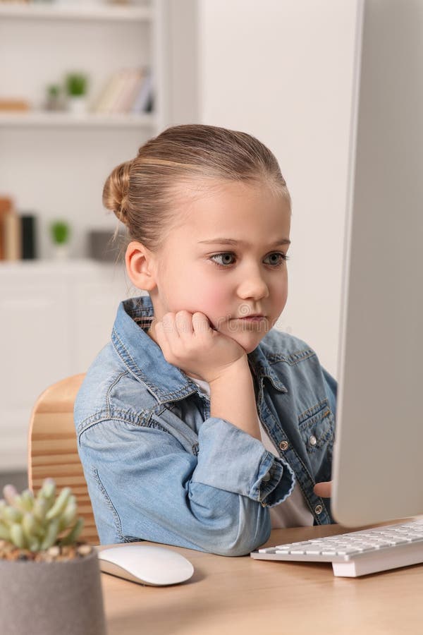 Little Girl Using Computer at Table in Room. Internet Addiction Stock ...