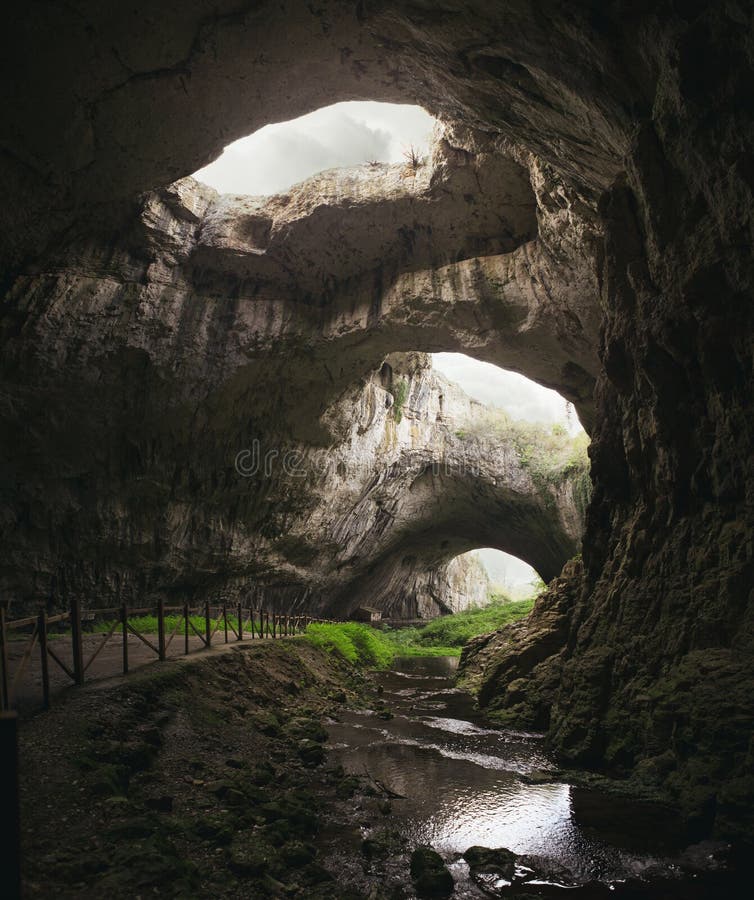 Man in Giant Cave with Light Coming from Outside Stock Photo - Image of ...