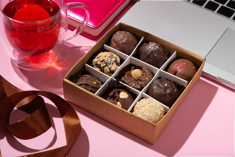 Gift Box with Craft Chocolate Candies and Cup of Tea on Pink Work ...