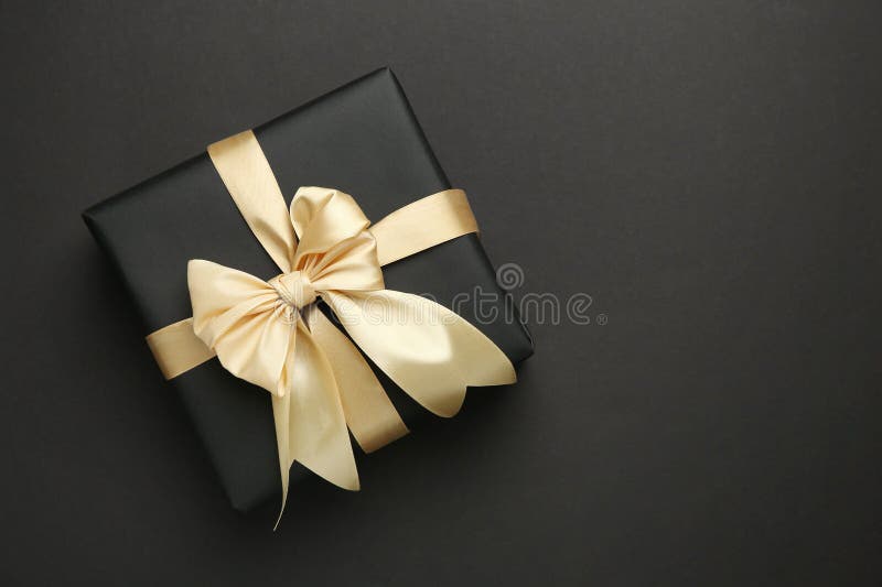 Gift Box with Golden Satin Bow on Black Background, Top View. Space for ...
