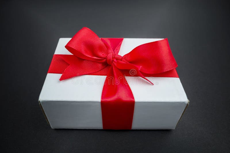 Gift Box with a Red Ribbon on a Black Surface Stock Image - Image of ...